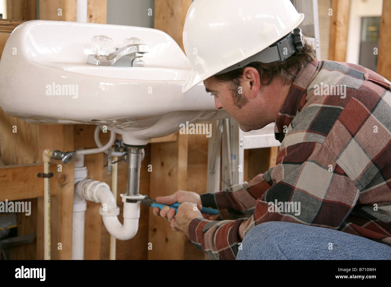A plumber in new home construction installing bathroom fixtures Focus ...
