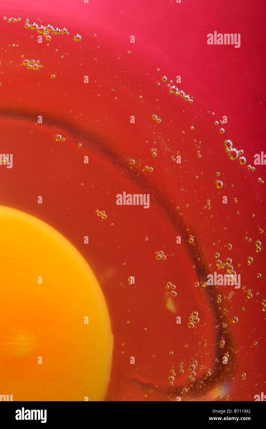 a raw egg in glass yolk yellow white pink orbital Stock Photo - Alamy