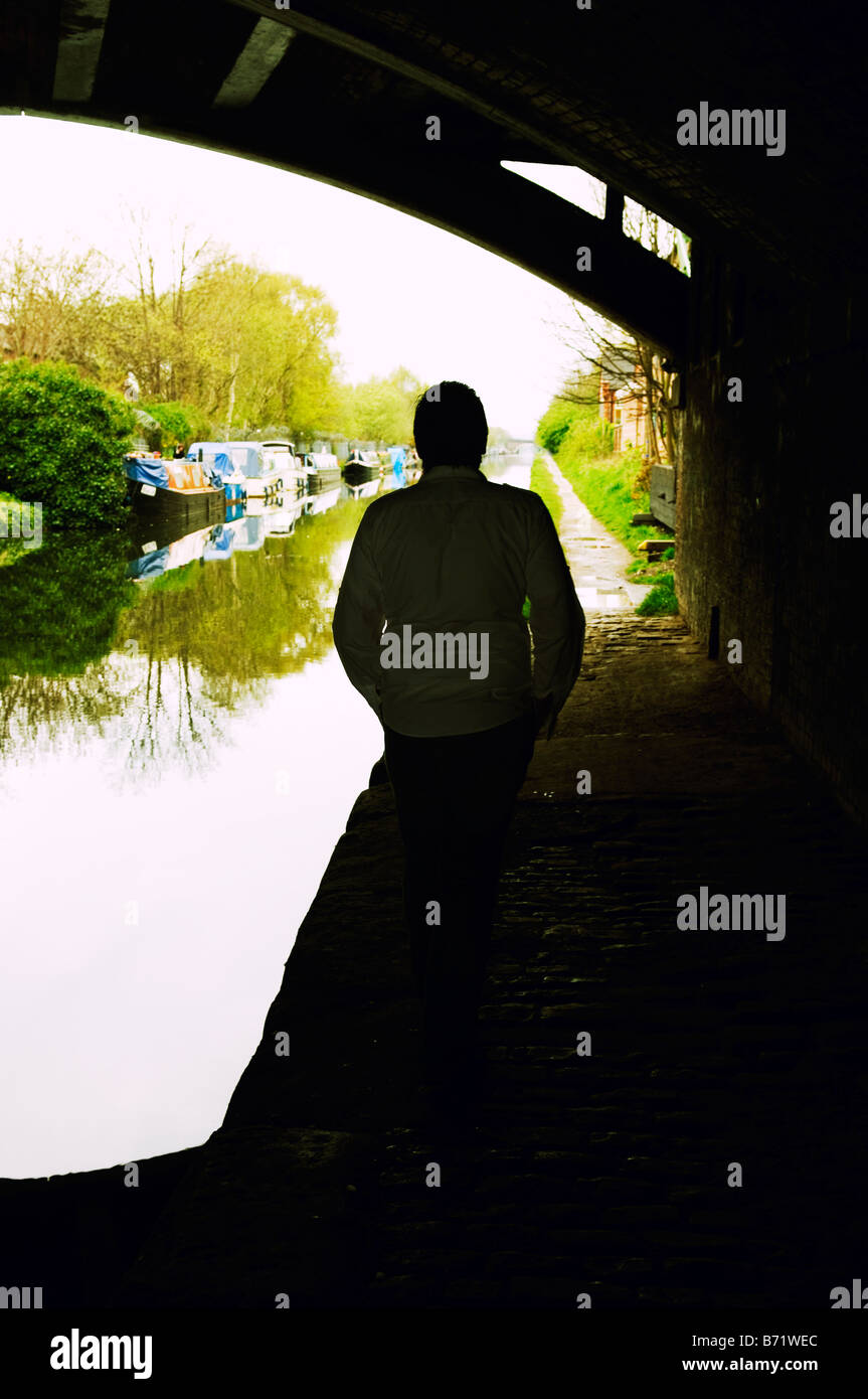 Silhouette of a man walking under bridge by the canal Stock Photo - Alamy