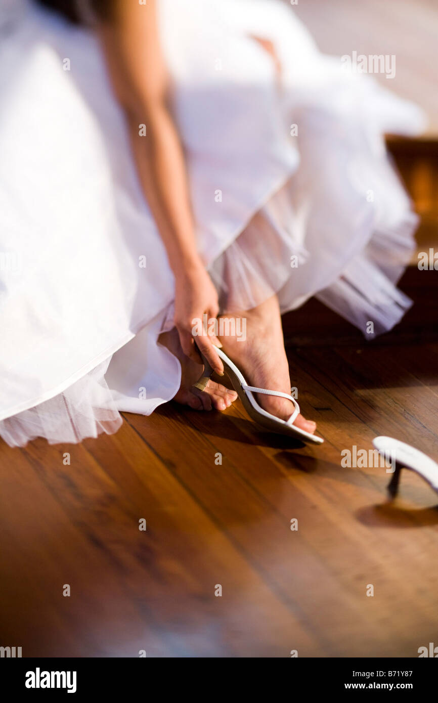 Bride reaching down to take off shoes Stock Photo - Alamy