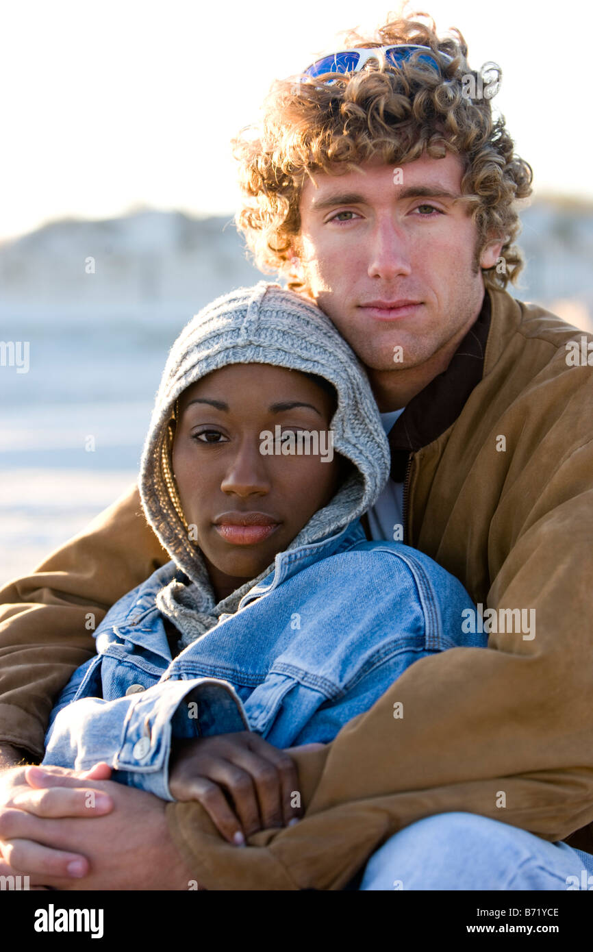 Interracial couple embracing looking camera hi-res stock photography ...