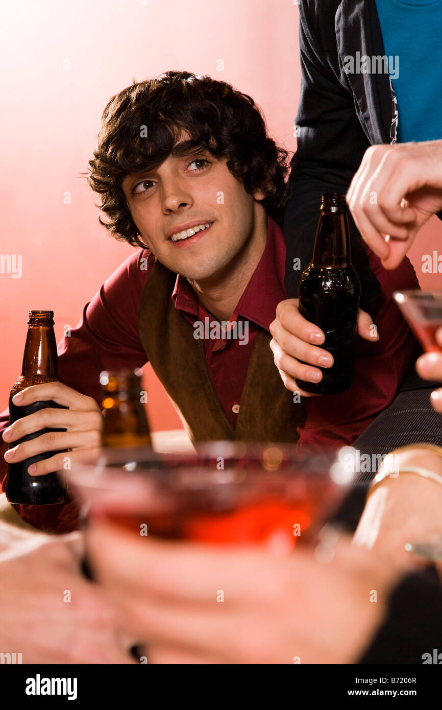 Young man drinking and socializing with friends Stock Photo - Alamy