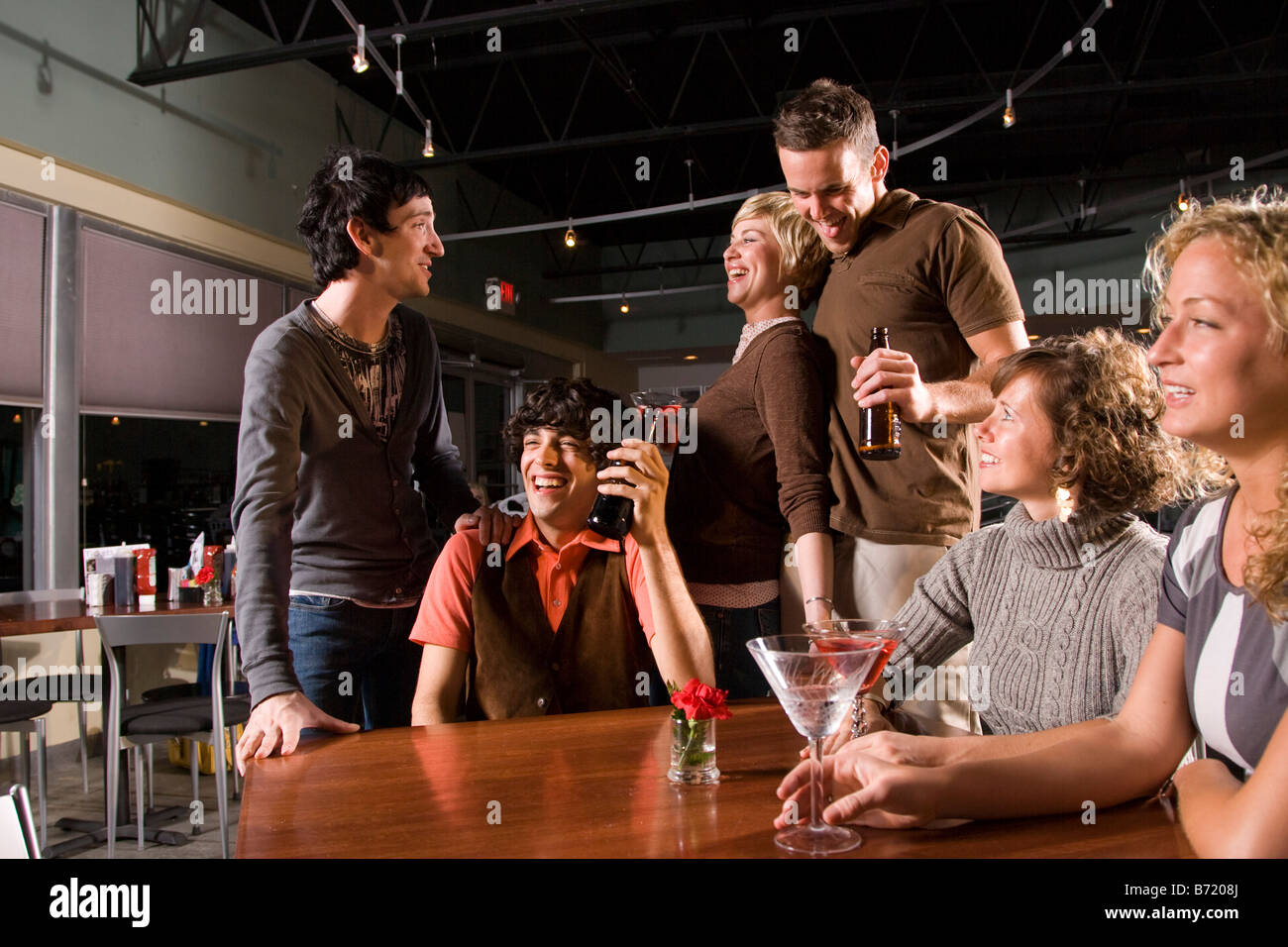 Young friends hanging out and drinking at bar together Stock Photo - Alamy