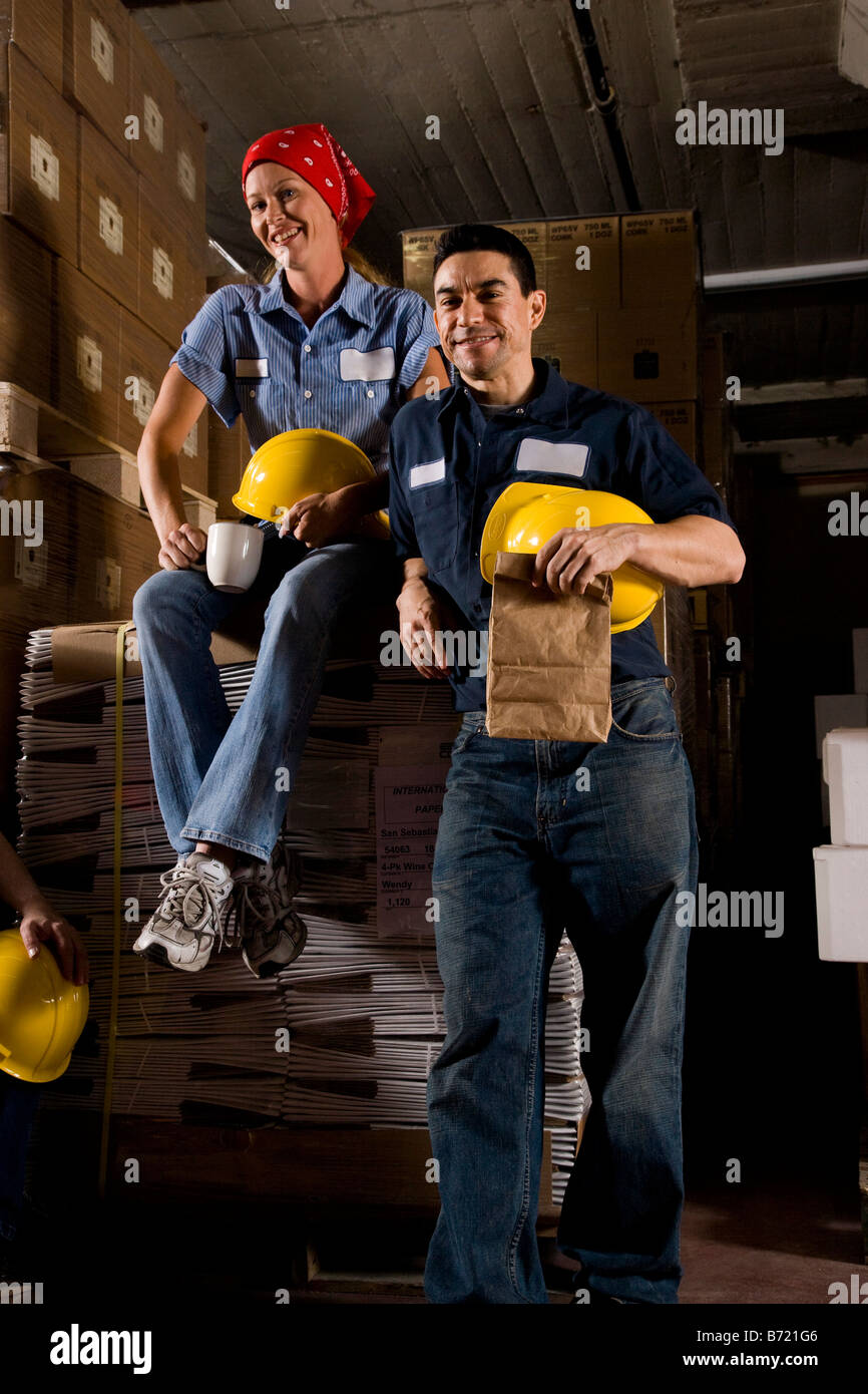 Two co-workers taking a coffee break in storage warehouse Stock Photo ...