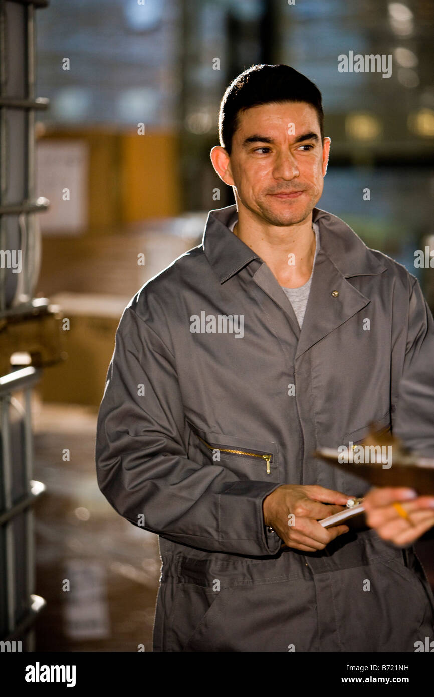 Male worker standing next to storage tank Stock Photo - Alamy