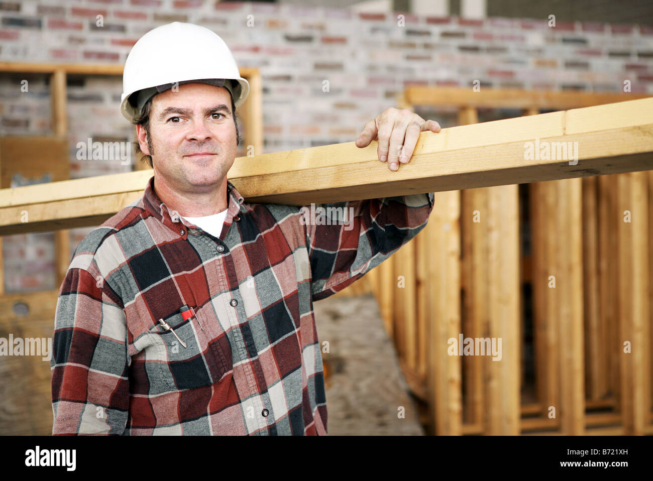 A construction day laborer carrying wood beams Authentic construction ...