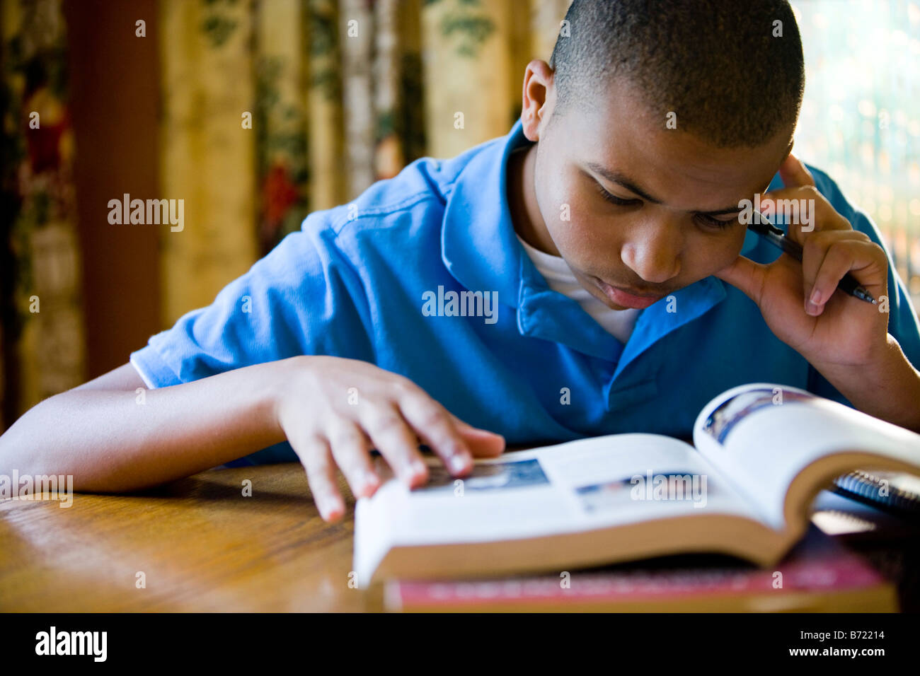 African American teenage boy doing homework Stock Photo - Alamy