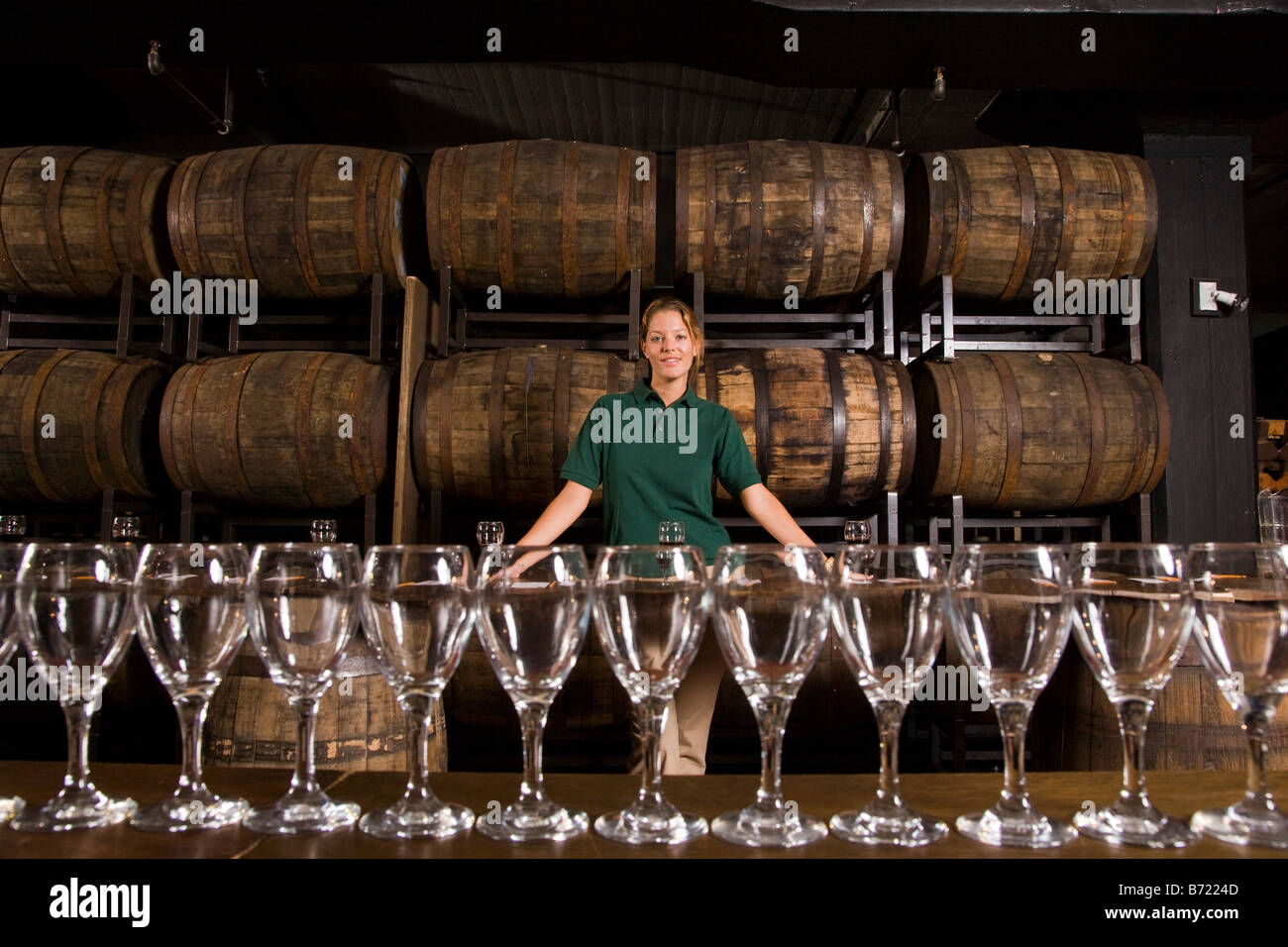 Winery tour guide posing in front of wine barrels Stock Photo - Alamy