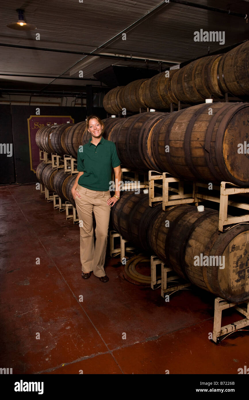 Winery tour guide posing beside wine barrels Stock Photo - Alamy