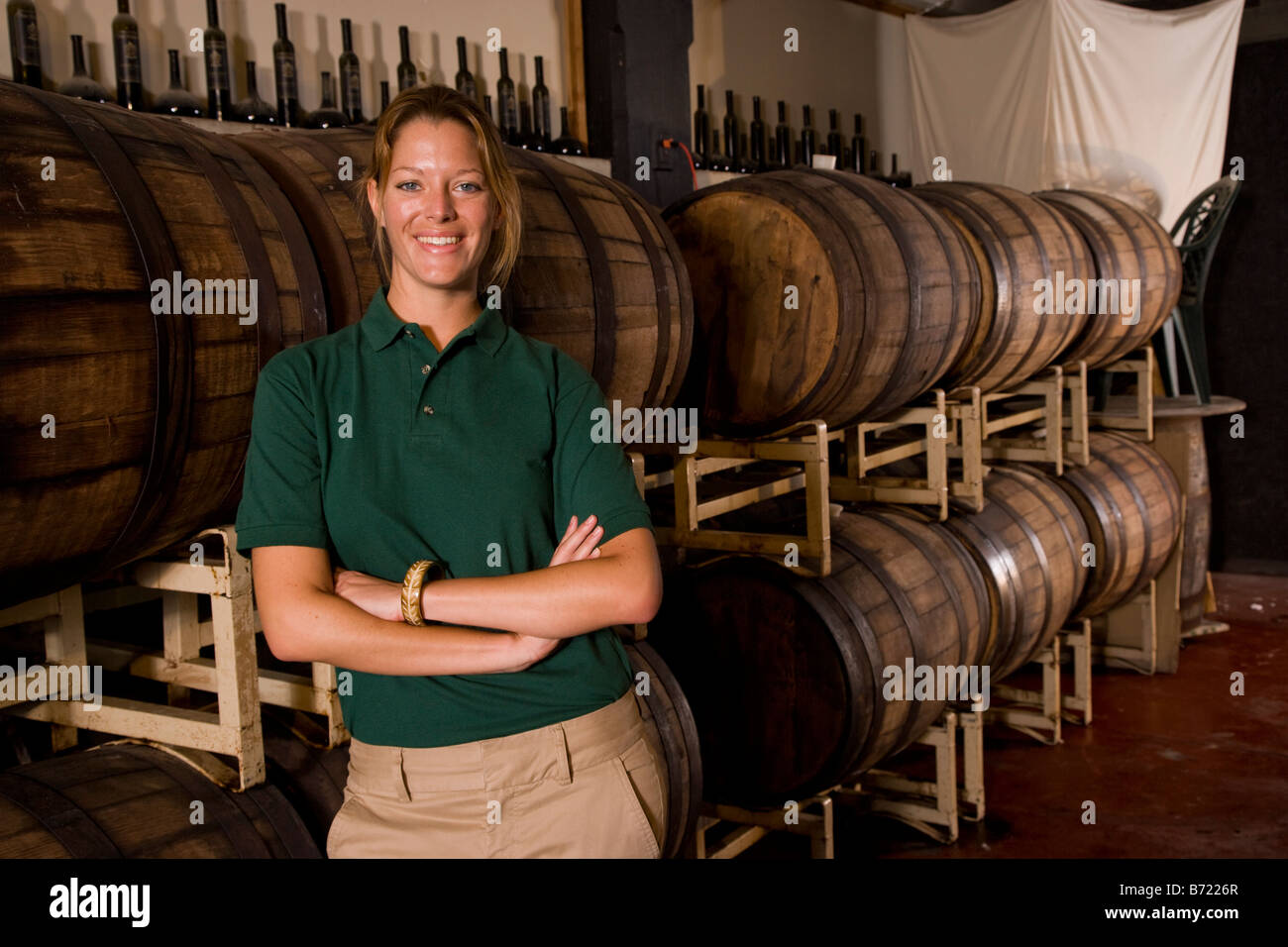 Winery tour guide posing beside wine barrels Stock Photo - Alamy