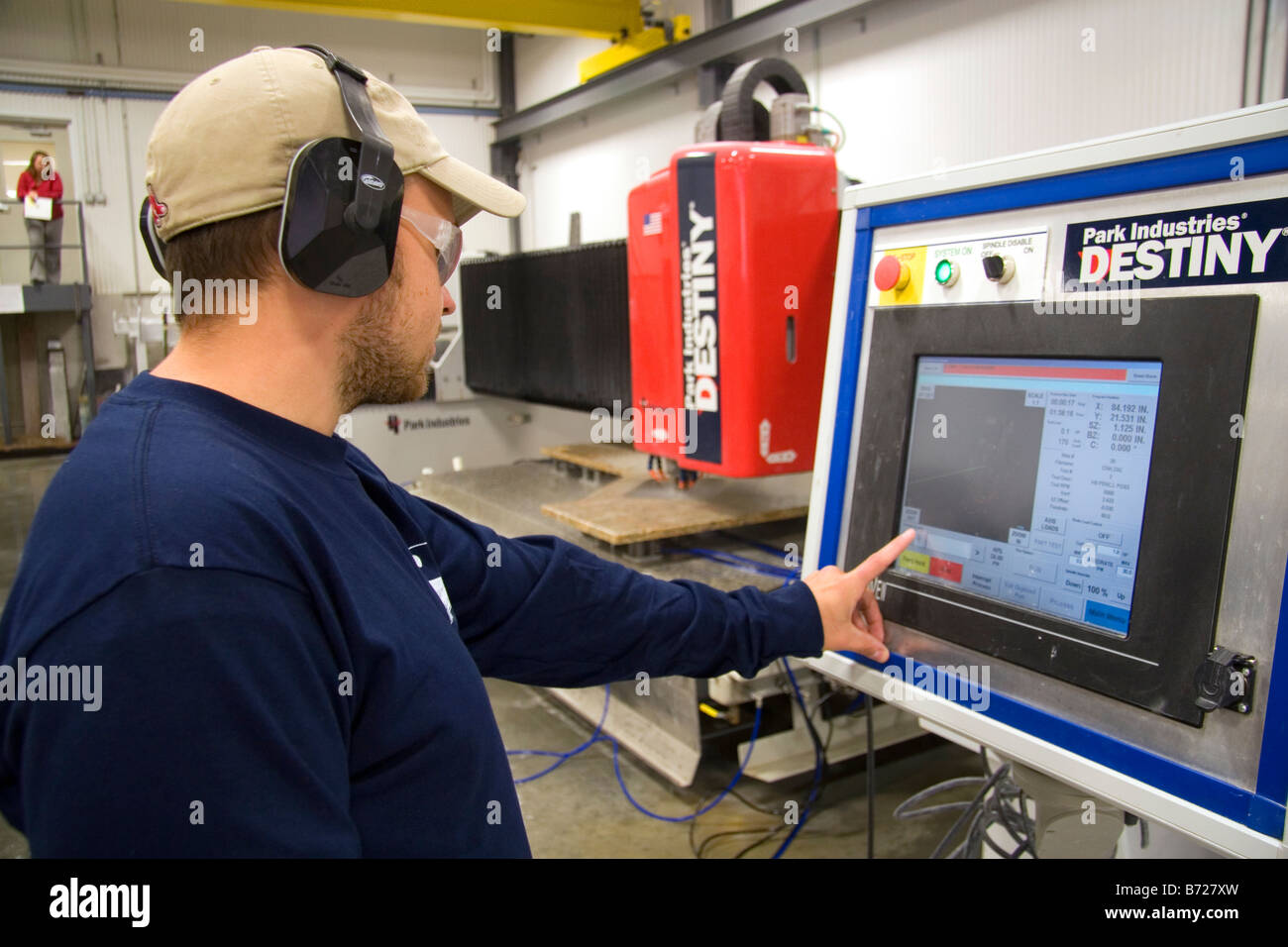 Worker using a computer to custom cut a granite countertop at the ...
