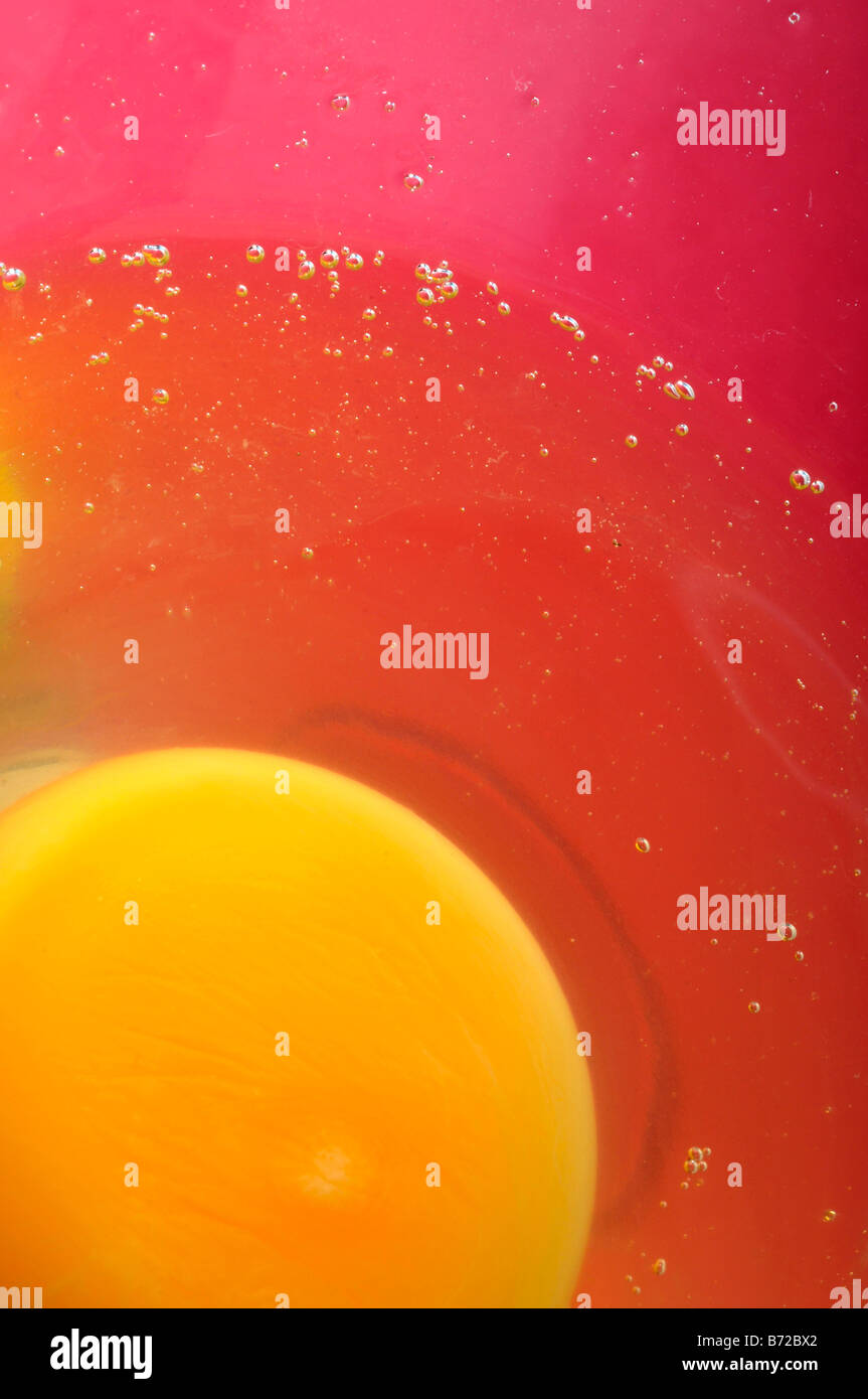 a raw egg in glass yolk yellow white pink orbital Stock Photo - Alamy