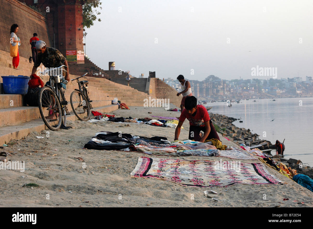 India Uttar Pradesh Varanasi man drying clothes on the Ganges River ...