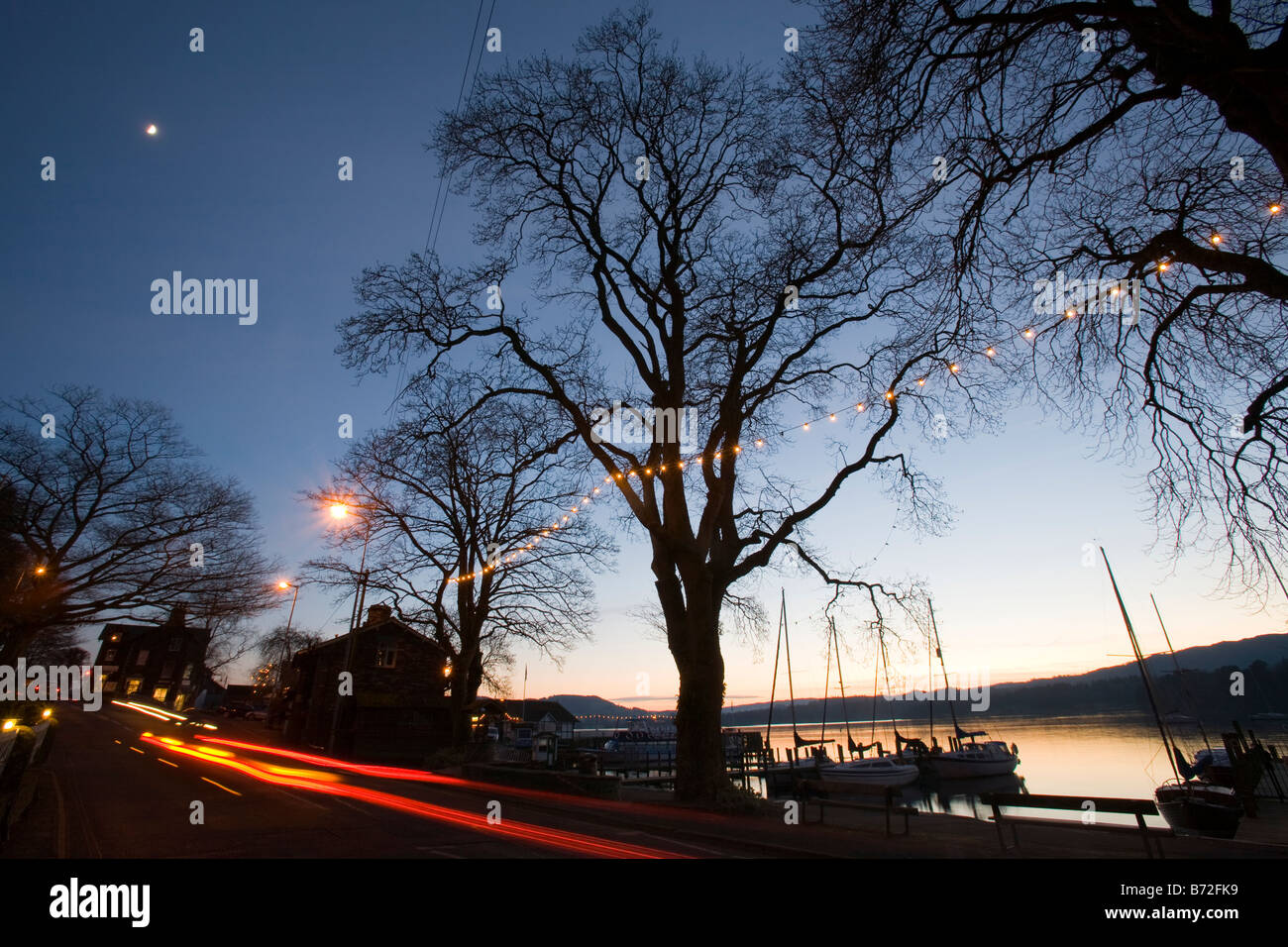 Windermere at sunset at Waterhead Ambleside UK with vehicle lights ...