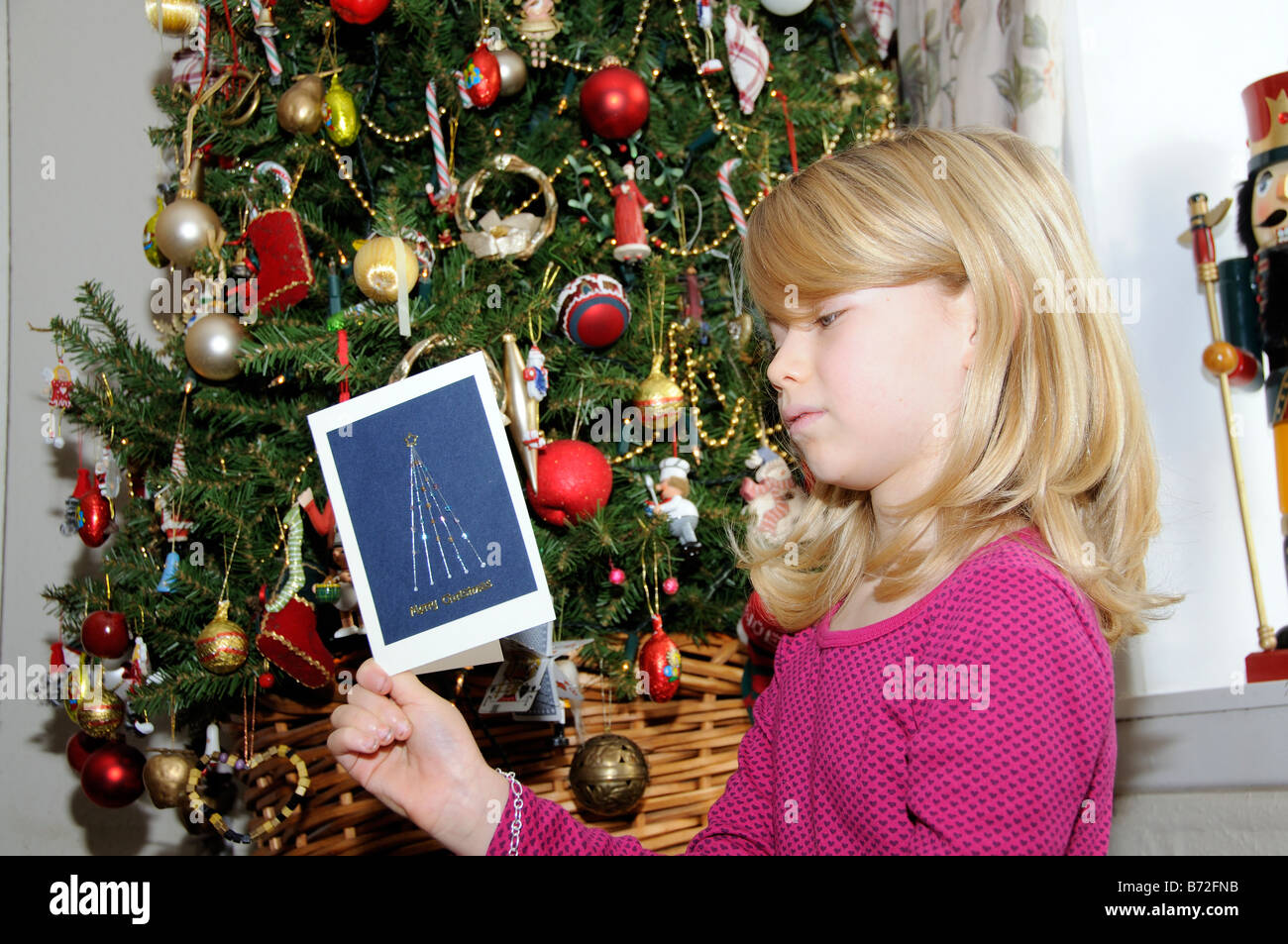 Little girl reading a christmas greeting card Stock Photo - Alamy