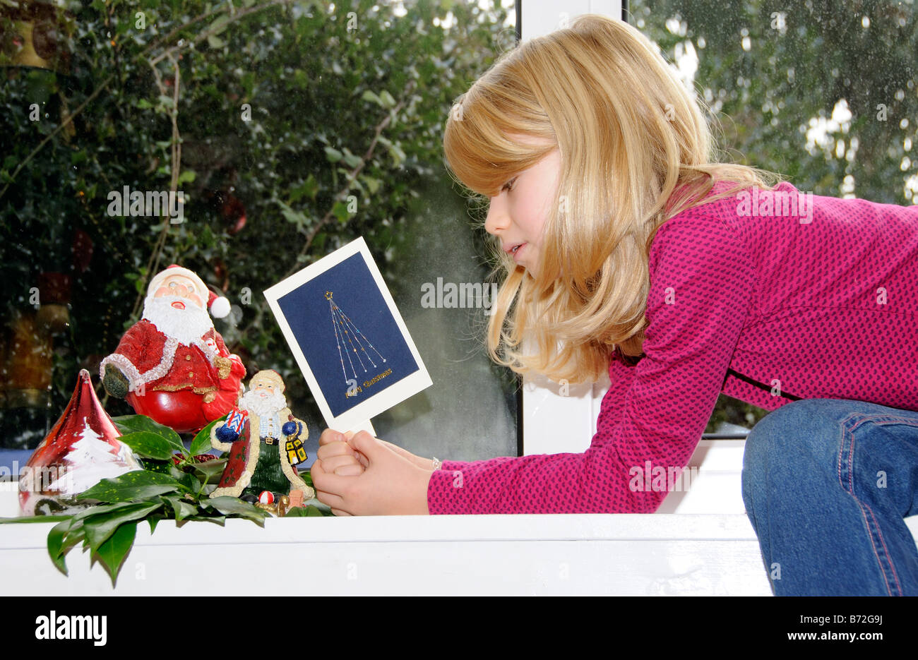 Little girl reading a christmas greeting card Stock Photo - Alamy
