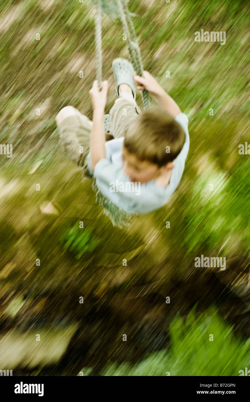Boy swinging on a rope swing Stock Photo - Alamy