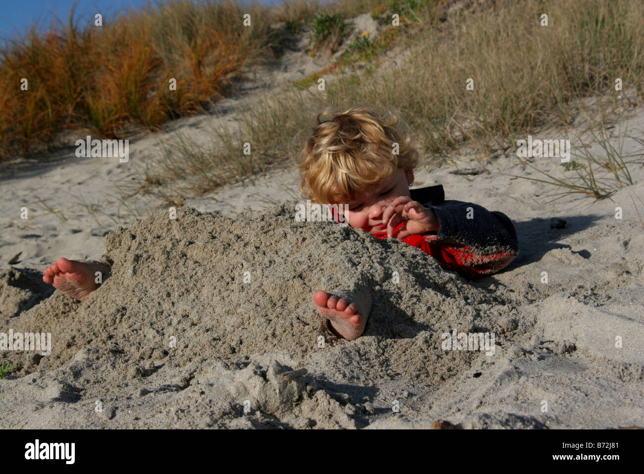 Boy buried in sand on hi-res stock photography and images - Alamy