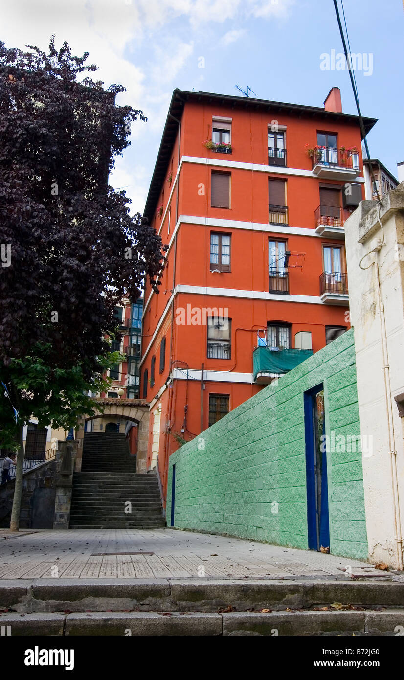 urban scenic of a green wall and a red building over a blue sky Stock ...