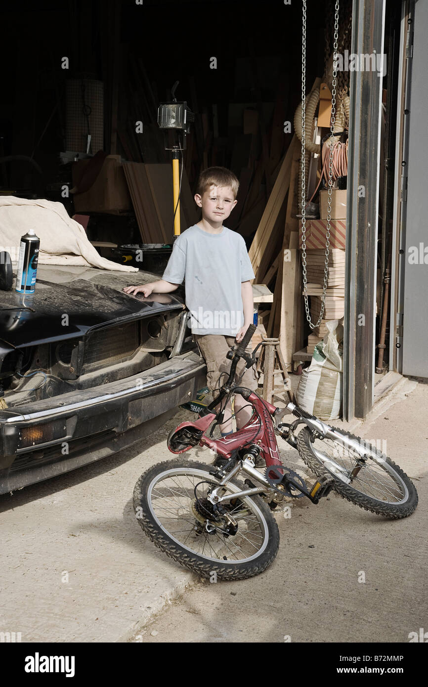 Boy standing with a car in a garage Stock Photo - Alamy