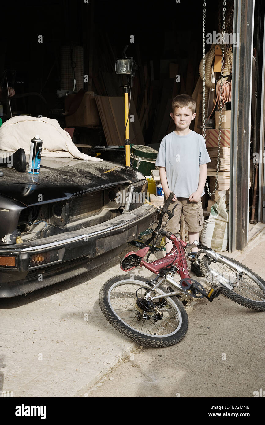 Boy standing with a car in a garage Stock Photo - Alamy