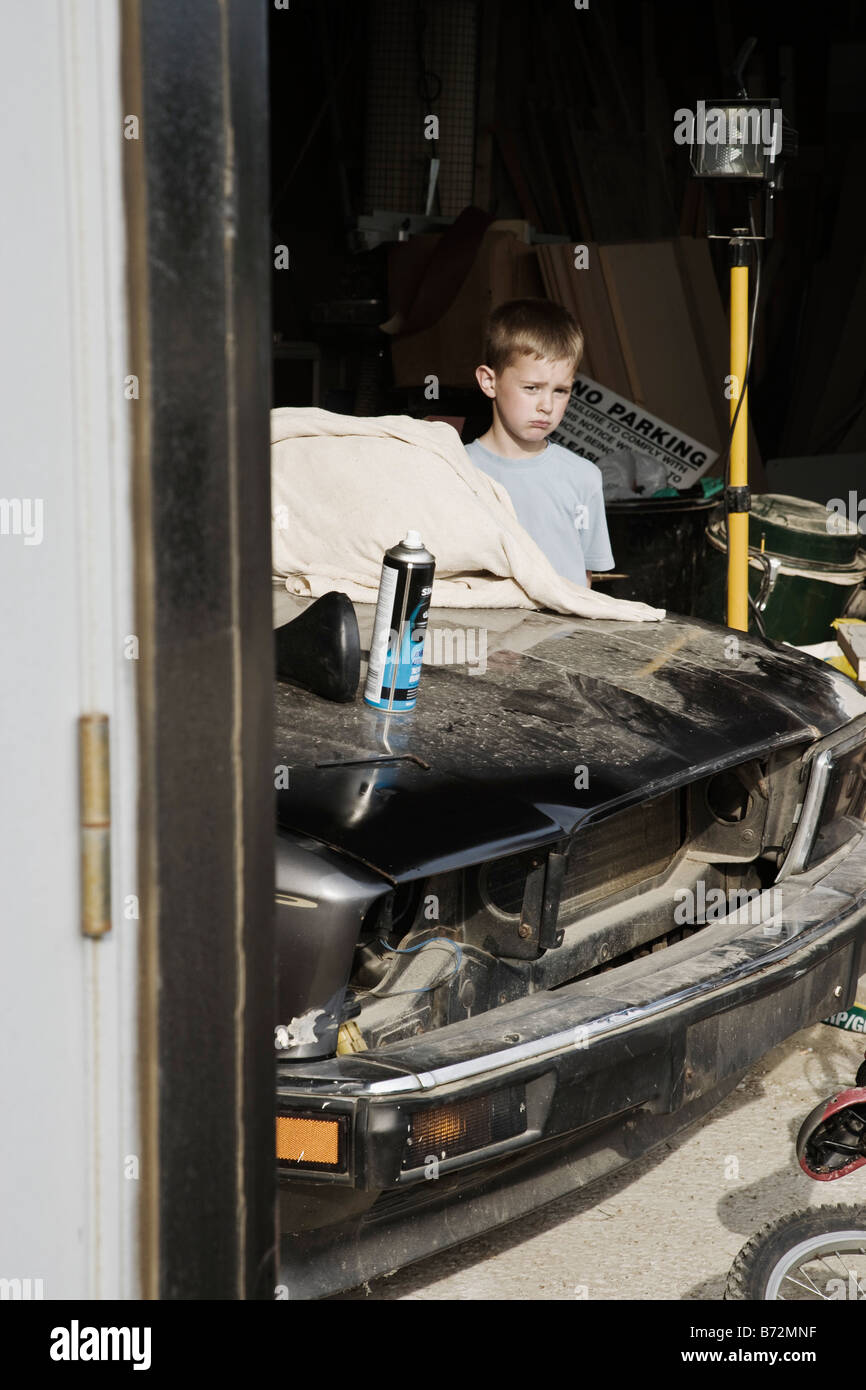 Boy standing behind a car in a garage Stock Photo - Alamy