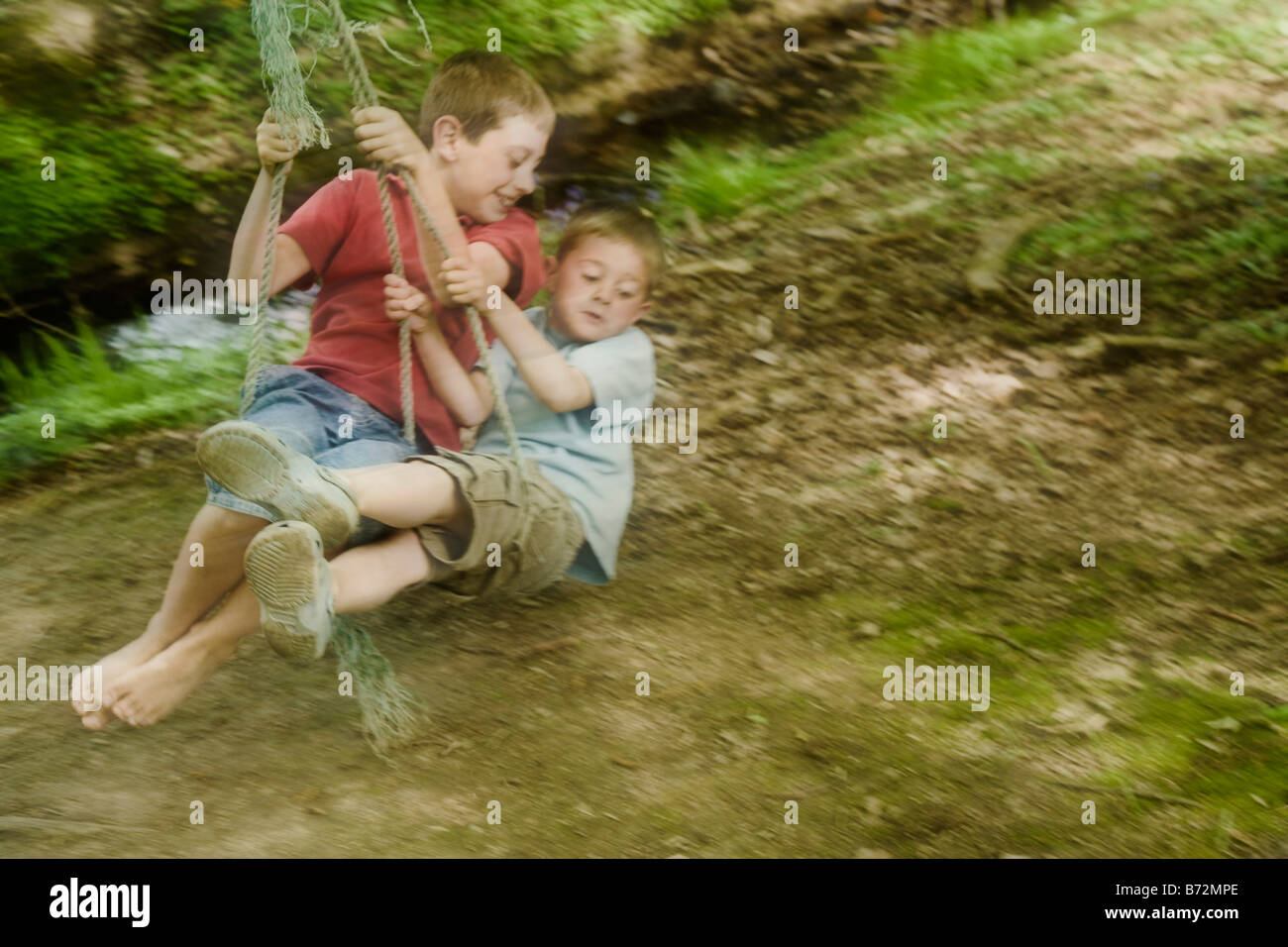 two boys on a rope swing Stock Photo - Alamy