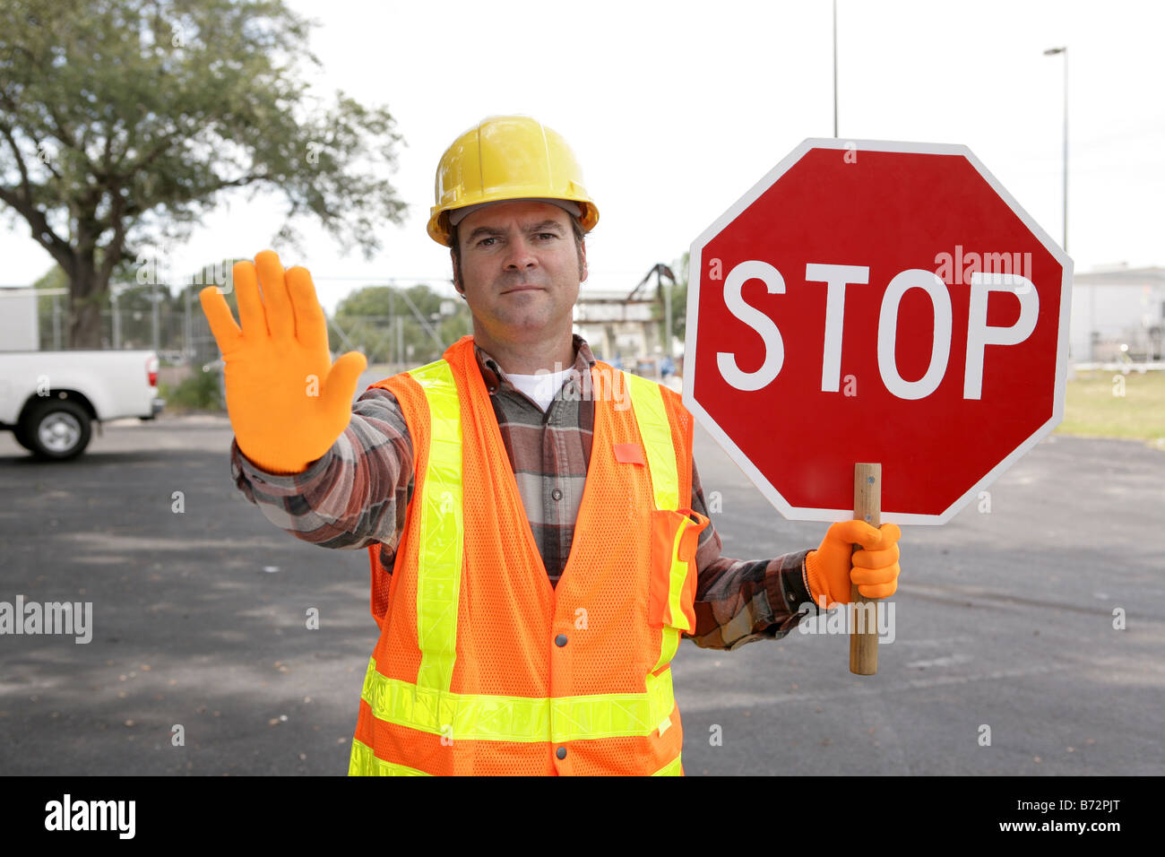 A construction worker holding a STOP sign and directing traffic Stock ...