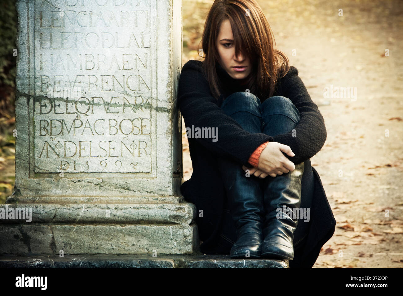 Sad woman sitting in a grave Stock Photo - Alamy