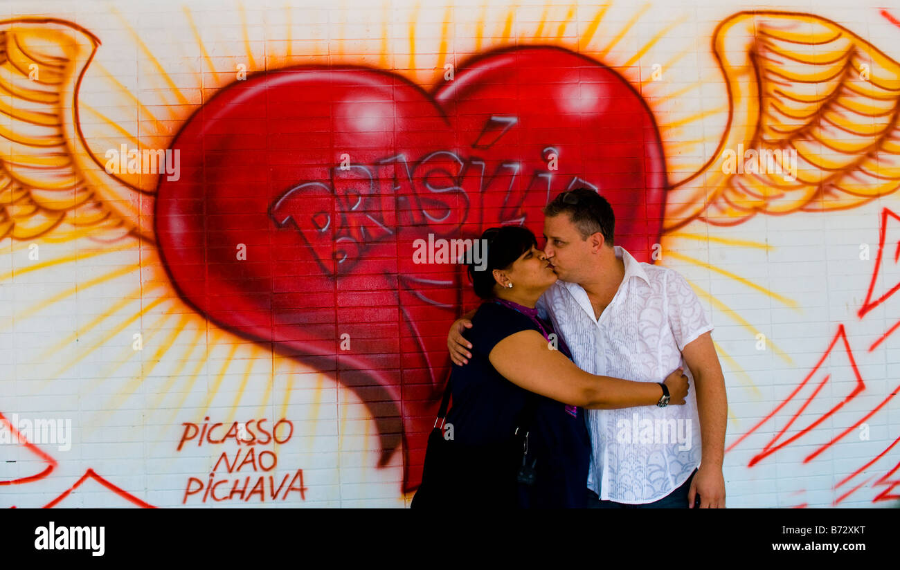 A kiss by a colorful graffiti painting in downtown Brasilia Stock Photo ...