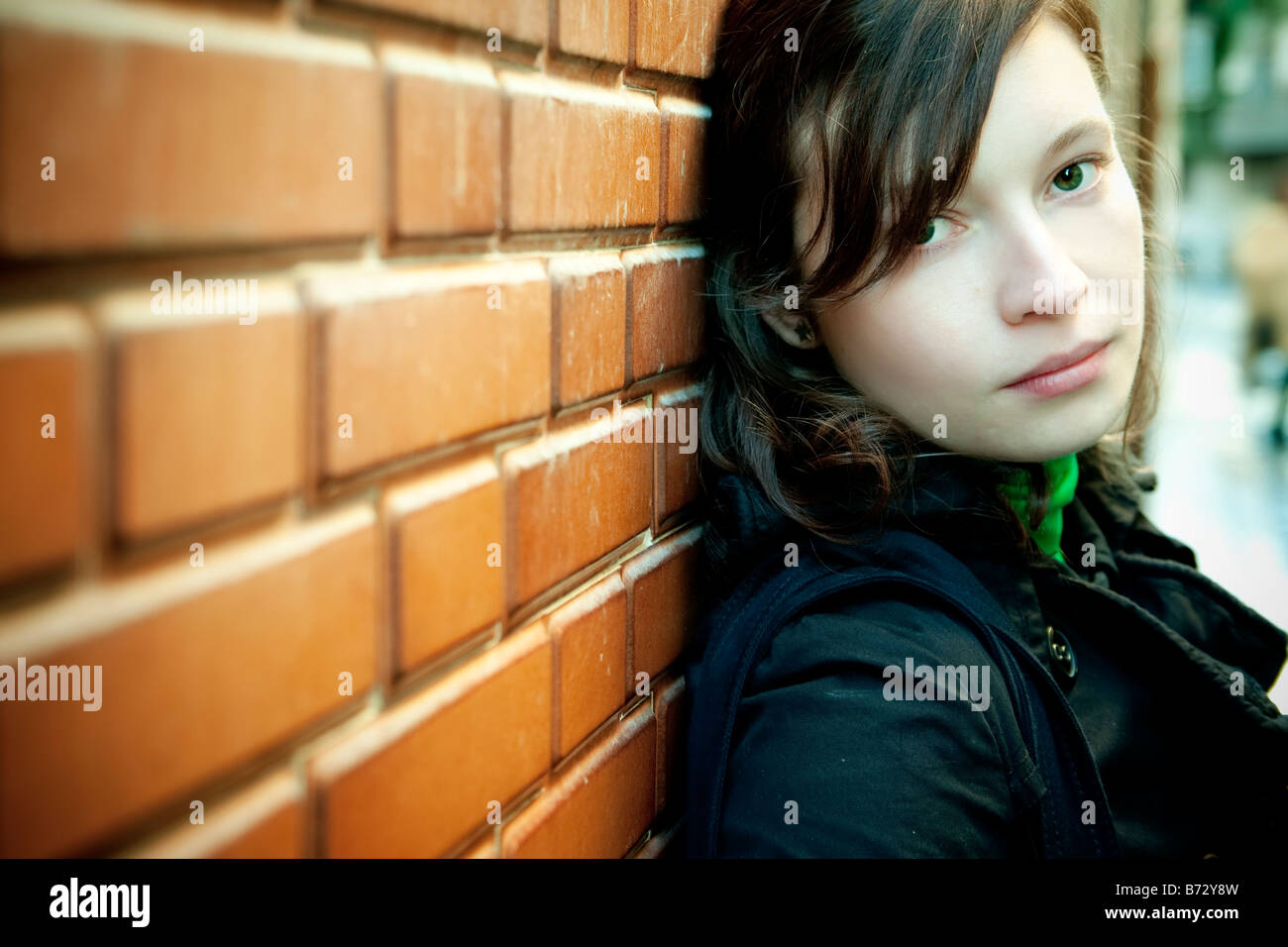 Beautiful girl waiting against brick wall Stock Photo - Alamy