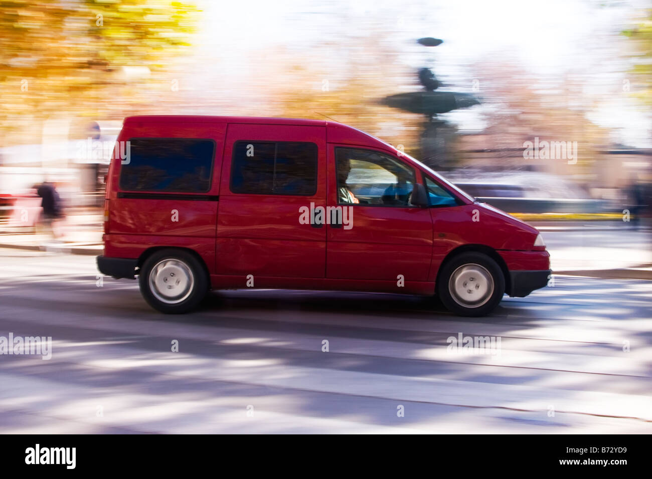 Red working vehicle at high speed in urban background Stock Photo - Alamy