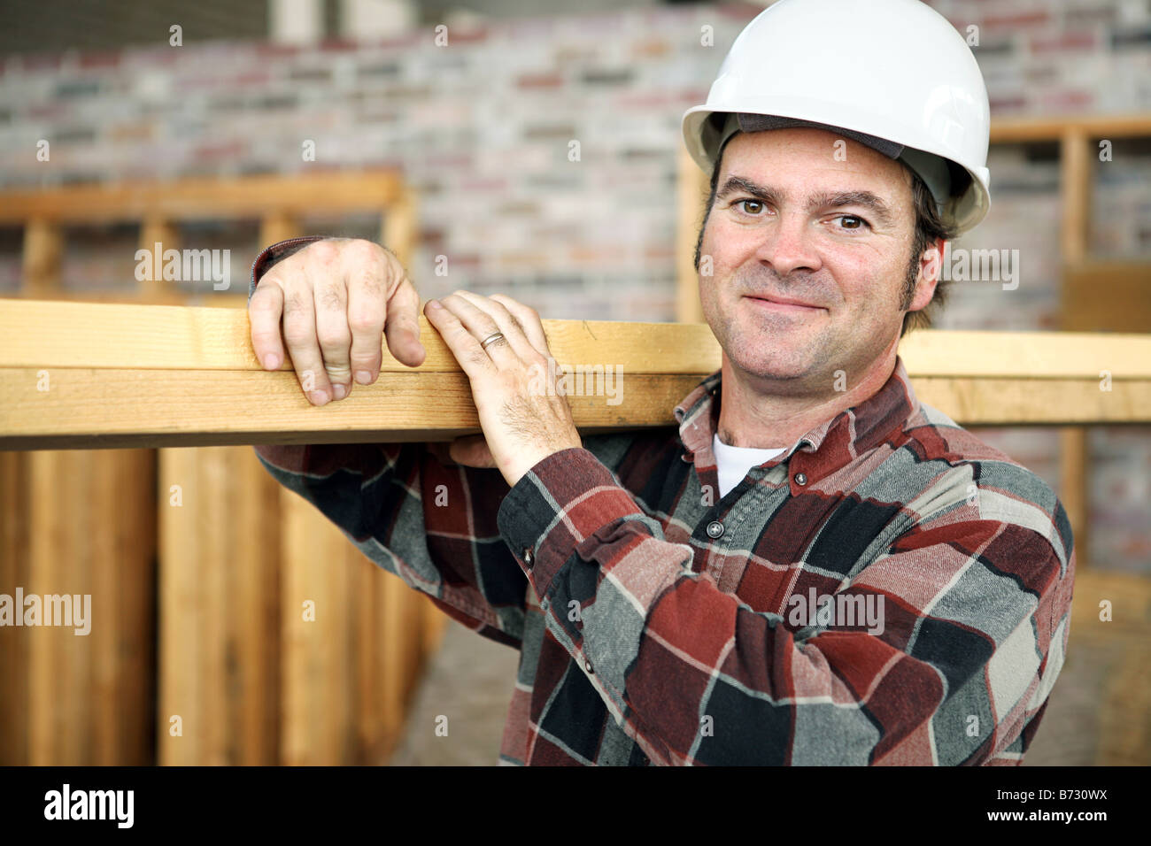 A friendly appealing construction worker in classic pose carrying ...