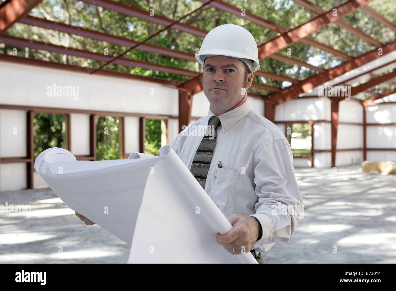 A construction engineer reviewing blueprints on the jobsite Stock Photo ...