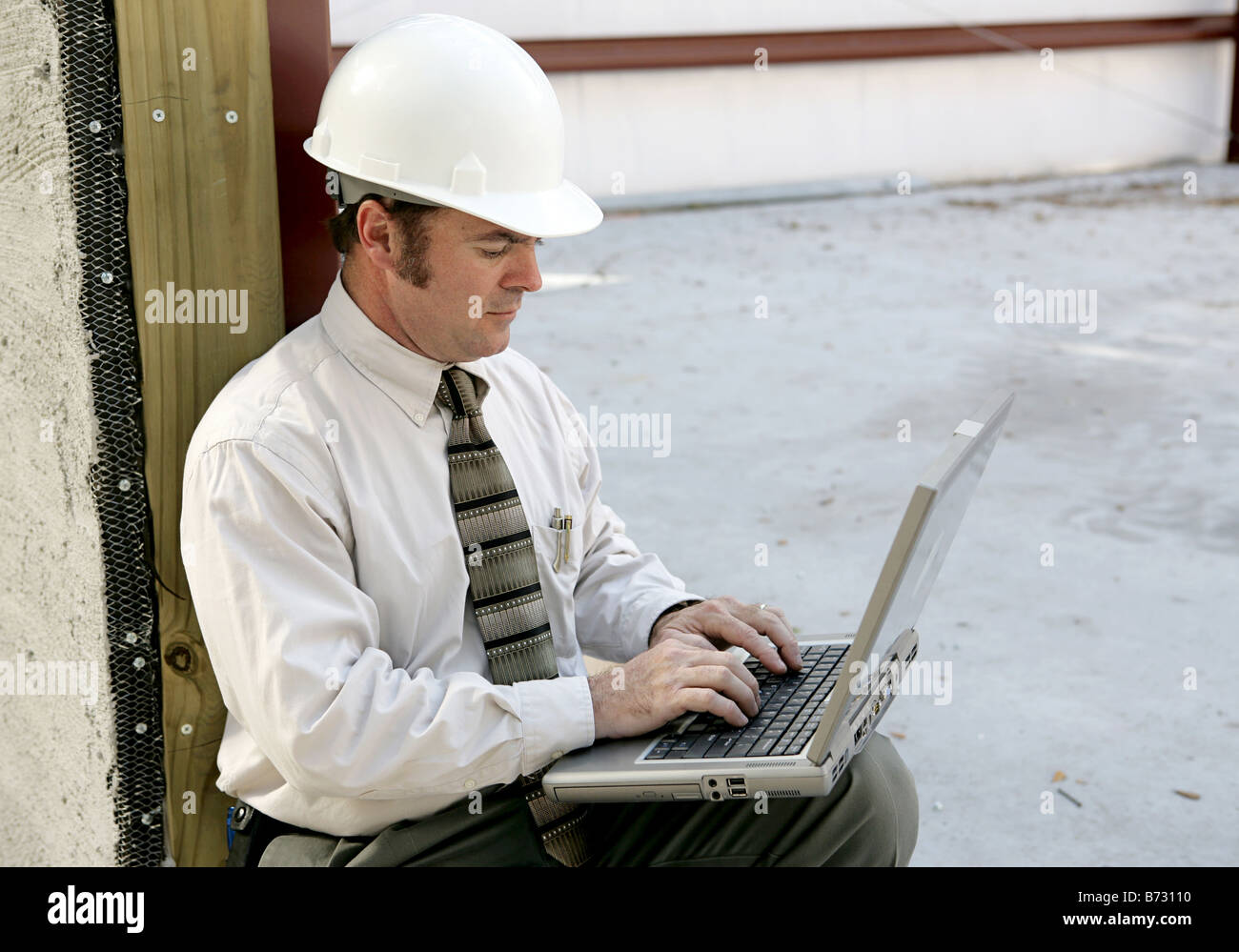 An engineer on a construction site using a laptop computer Stock Photo ...