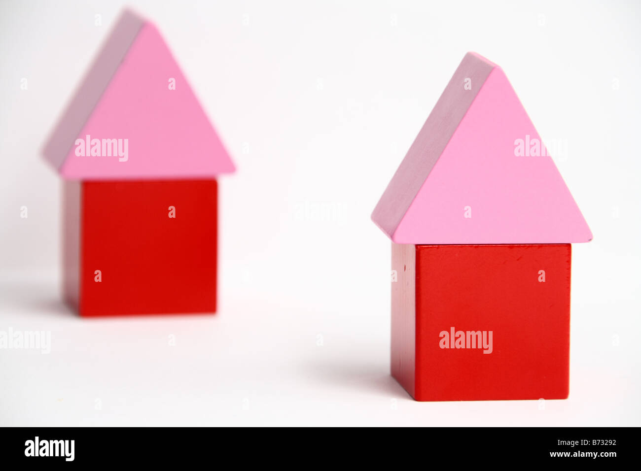 Two houses built of children's building blocks isolated on white ...