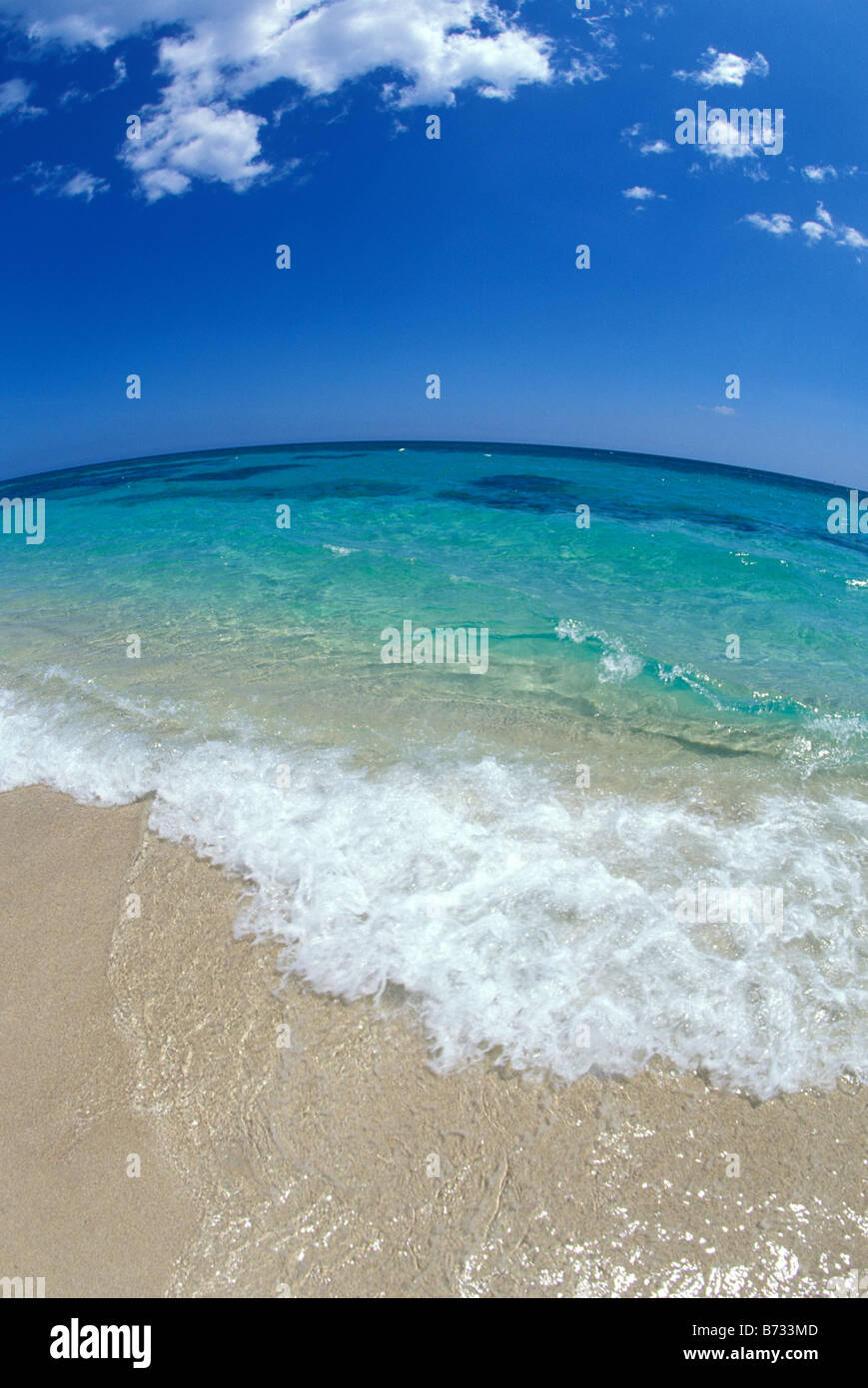 Curved horizon with waves breaking onto sandy beach Stock Photo - Alamy