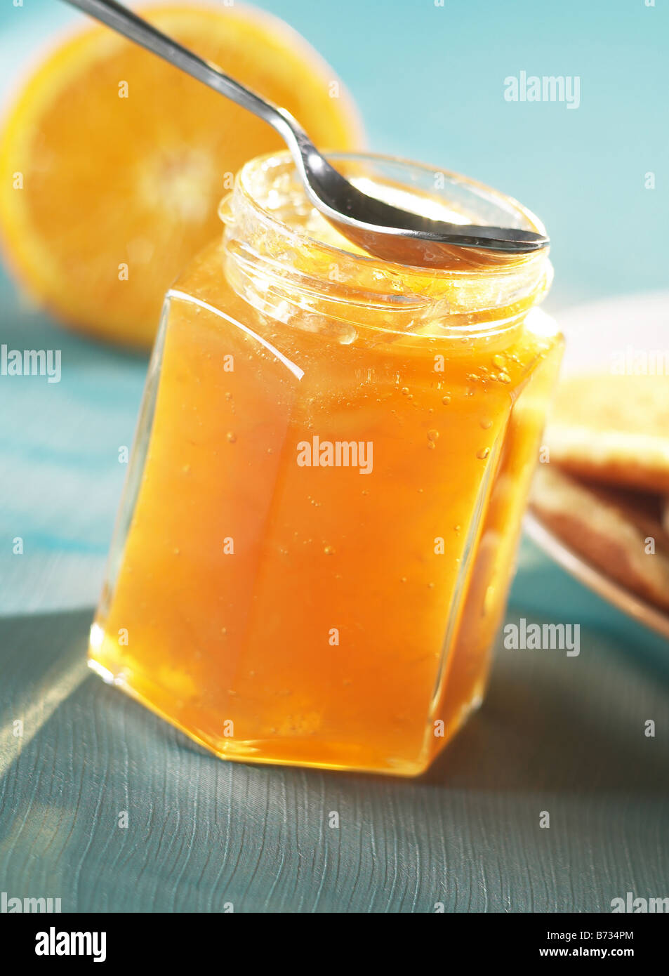 jar of marmalade with spoon and orange in background Stock Photo - Alamy