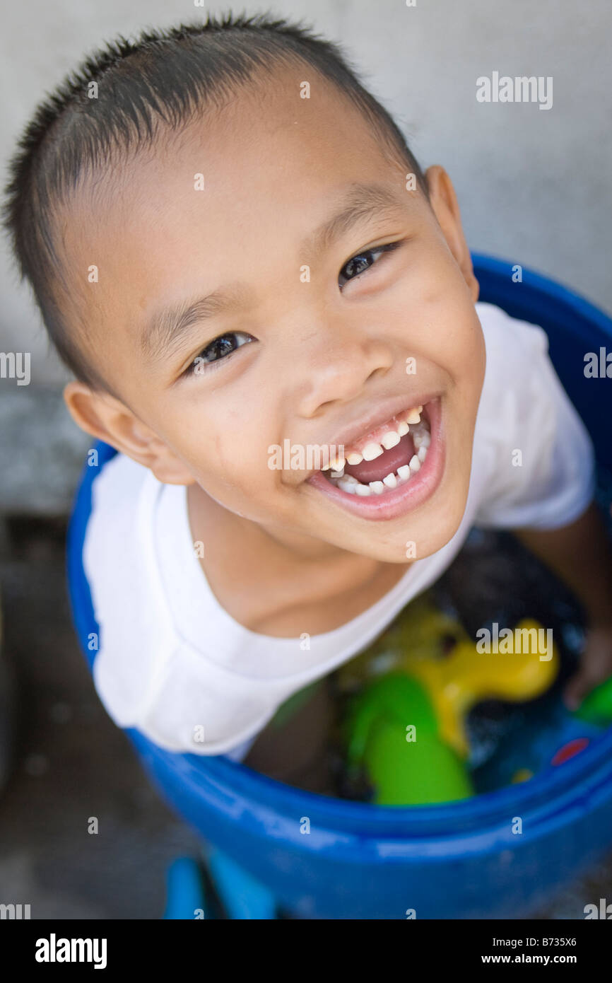A Thai boy having fun playing in a bucket of water boy, Thailand Stock ...