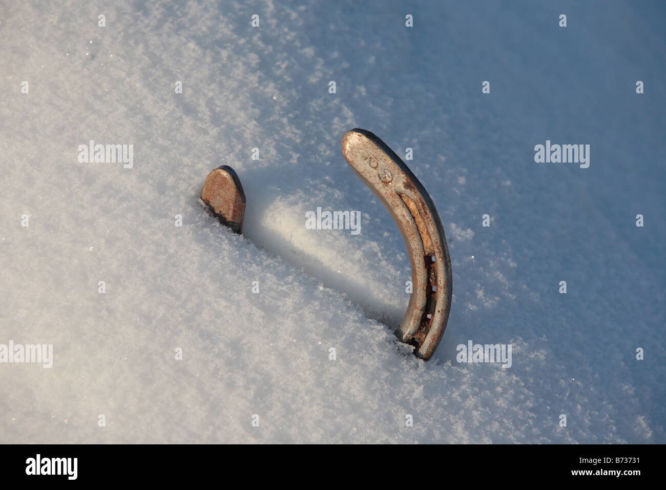 Good luck horse shoe in snow Stock Photo - Alamy