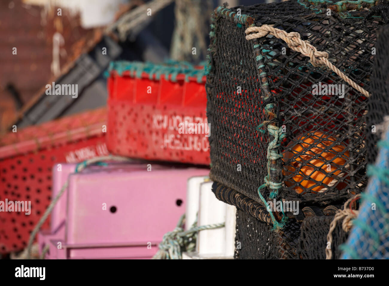 lobster pots and fishing crates piled up on a pier in portavogie county ...