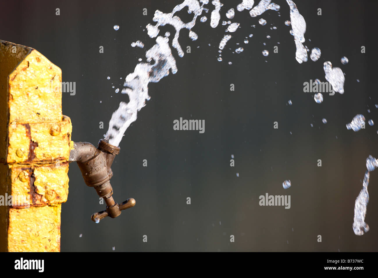 upside down outdoor tap left running with water flowing out and upwards ...