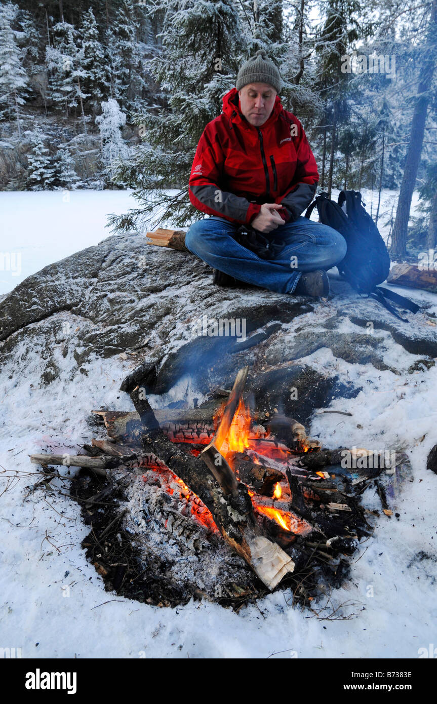 Man warms up by camp fire in snow and cold near Oslo Norway Stock Photo ...