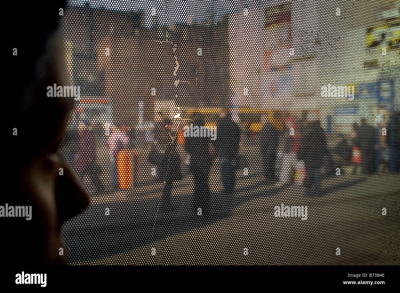 View through a textured bus window of passengers in a bus station in ...