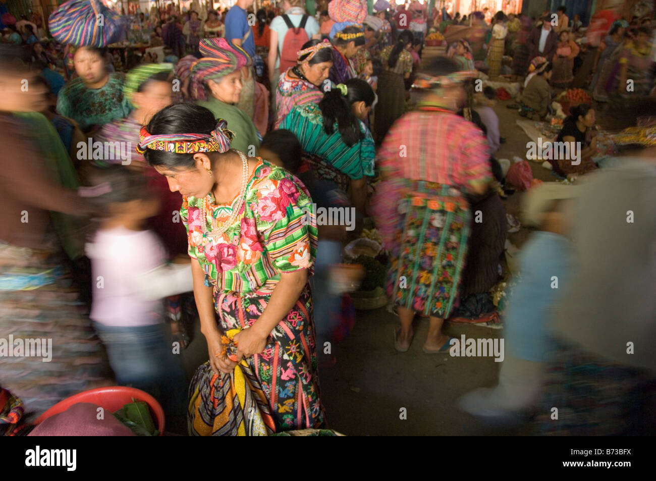 Maya woman of K'iche origin amidst the moving crowd on the market of ...