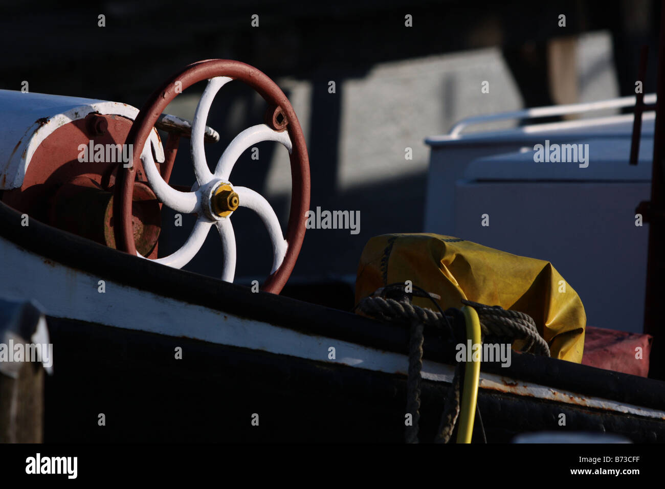 A ship's wheel on a houseboat in the river Deben, Woodbridge, Suffolk ...