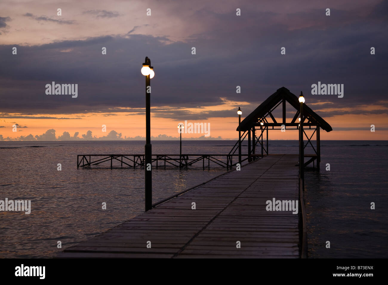 Sunset over Indian Ocean with along wooden walkway Mauritius Stock ...
