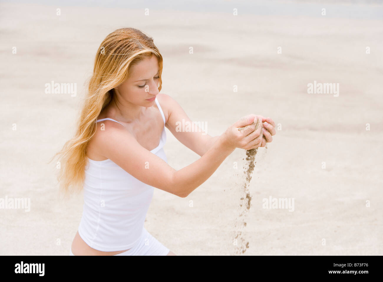 Woman sifting sand through her hands Stock Photo - Alamy