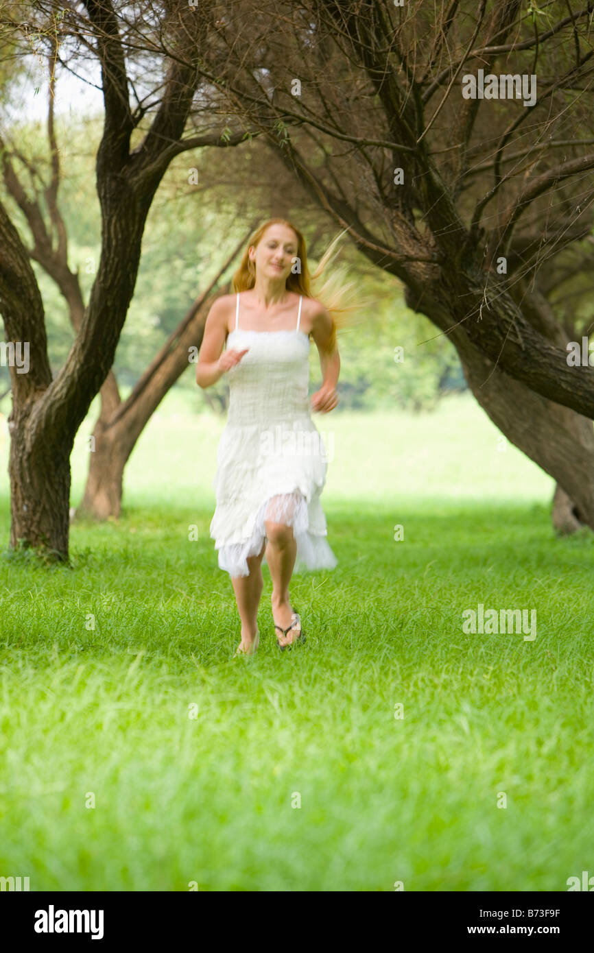 Young woman running on grass Stock Photo - Alamy