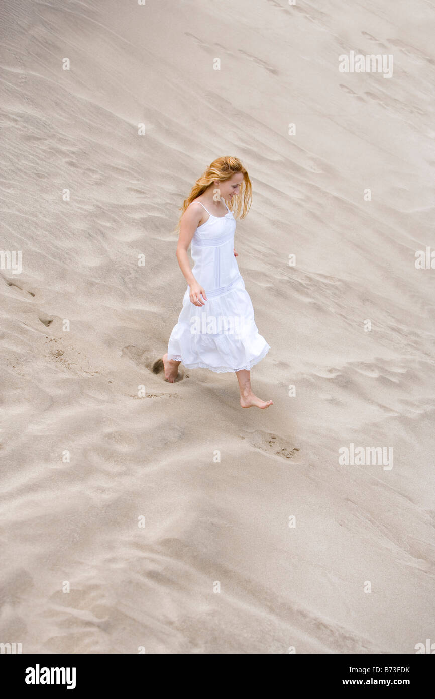 Young woman walking on sand Stock Photo - Alamy